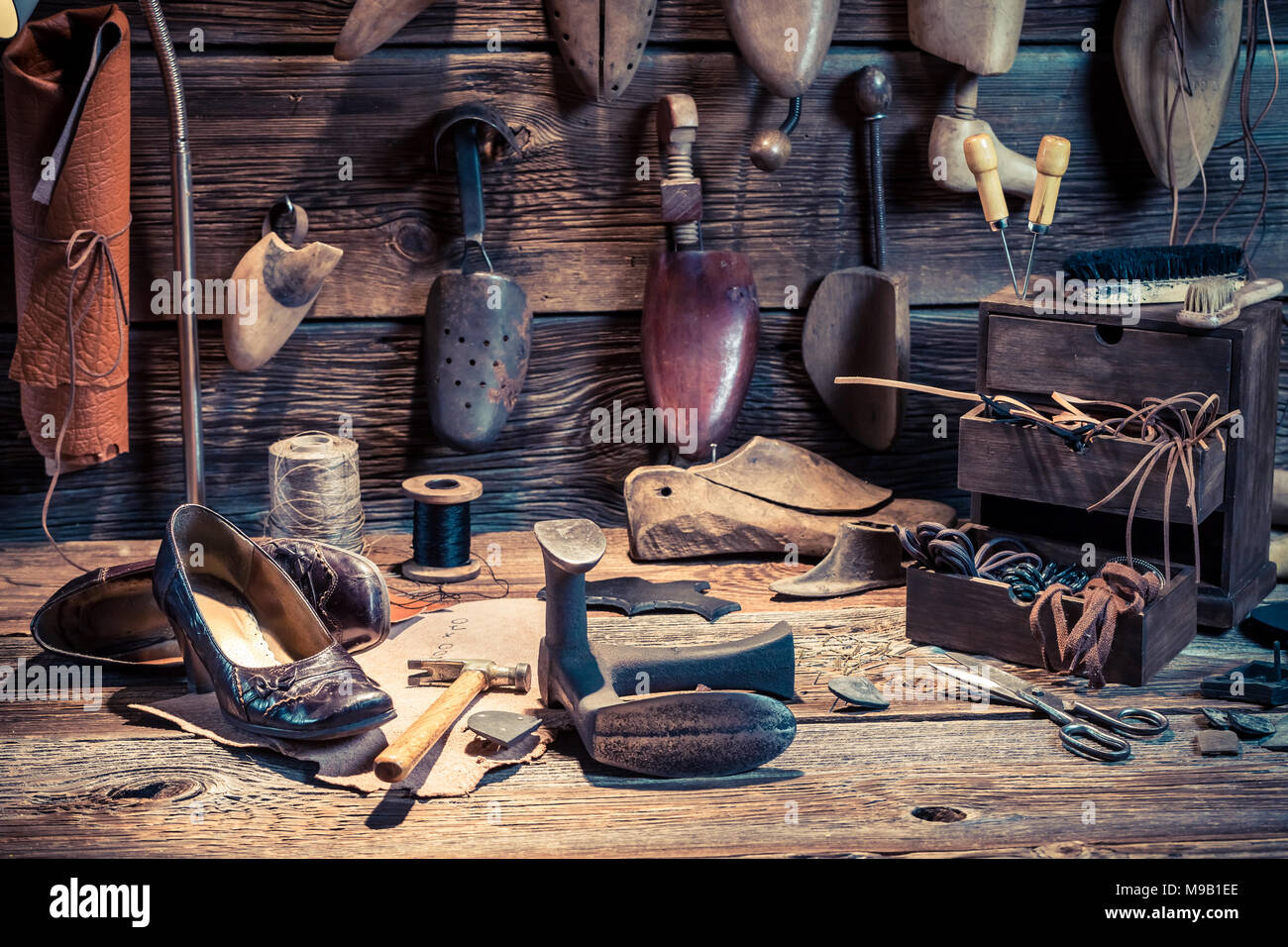 Cobbler workshop with laces, tools and shoes Stock Photo - Alamy