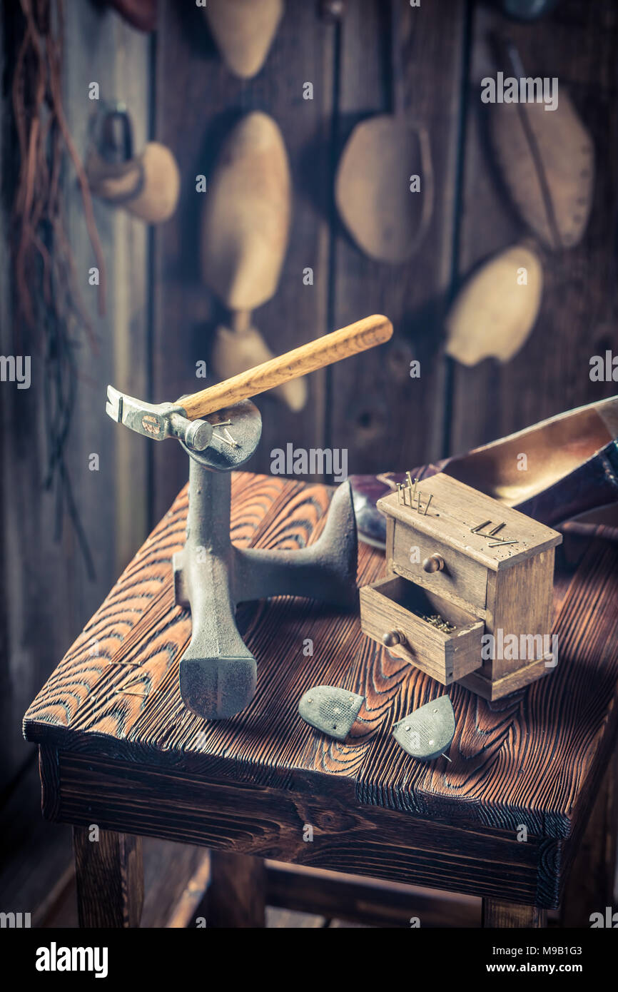 Hammer, nails and shoes in shoemaker workplace Stock Photo - Alamy