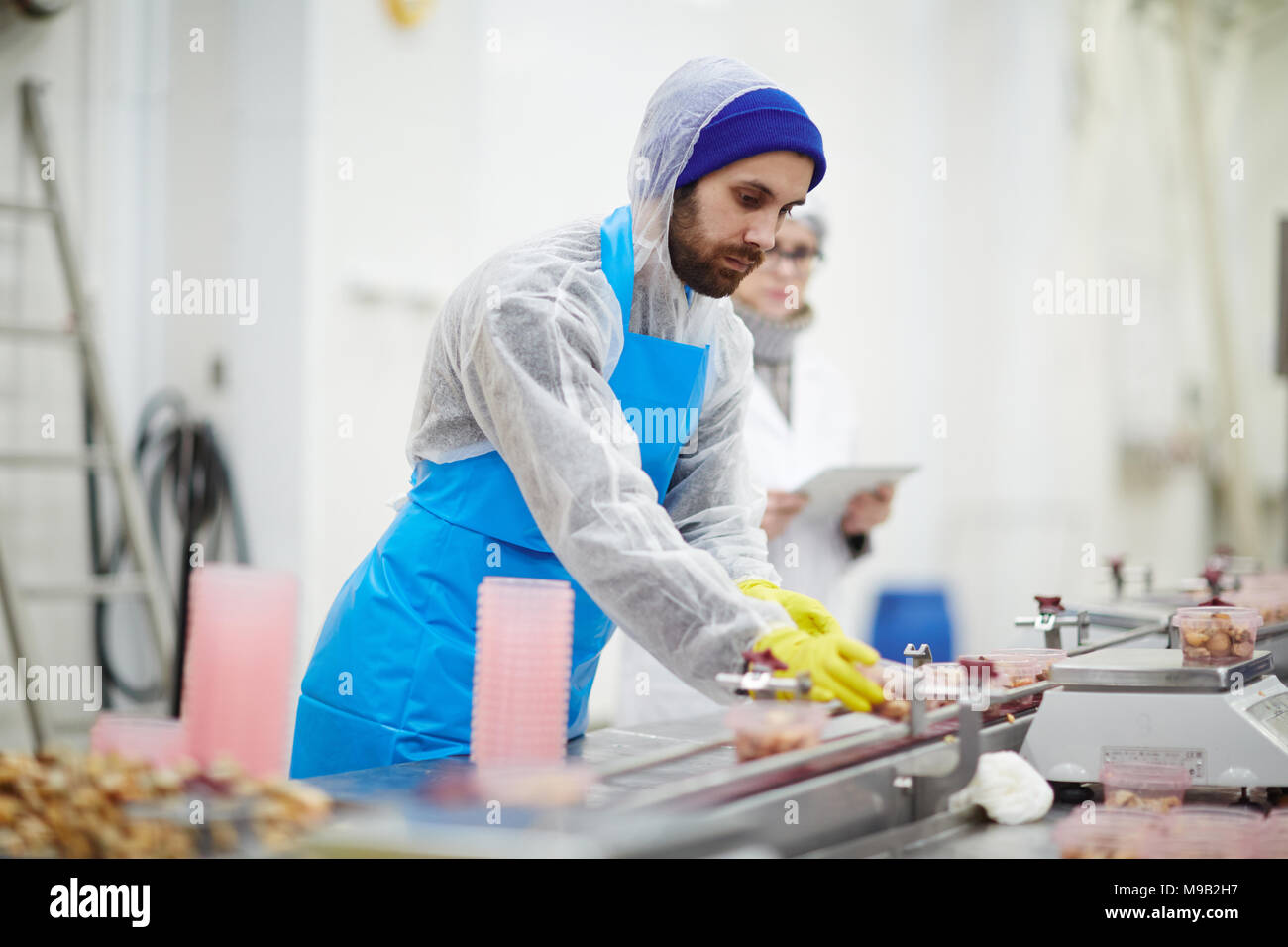 Man by production-line Stock Photo - Alamy