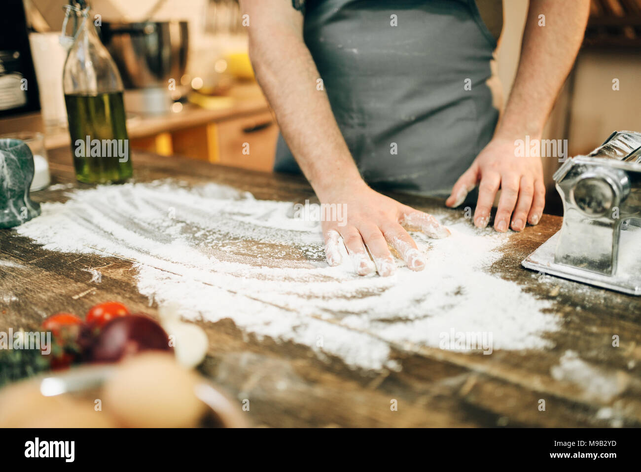 Chef in apron, flour,eggs, pasta machine on table Stock Photo - Alamy
