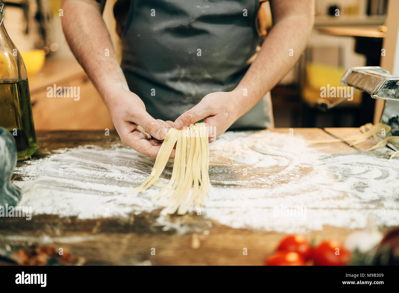 Male chef cooking dough and prepares pasta machine Stock Photo - Alamy