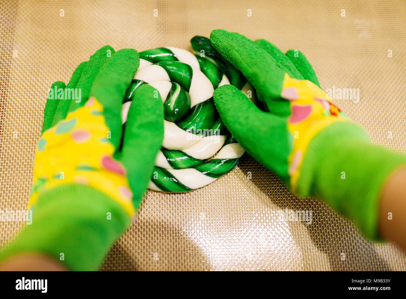 Kid hands in gloves making caramel sweets Stock Photo - Alamy