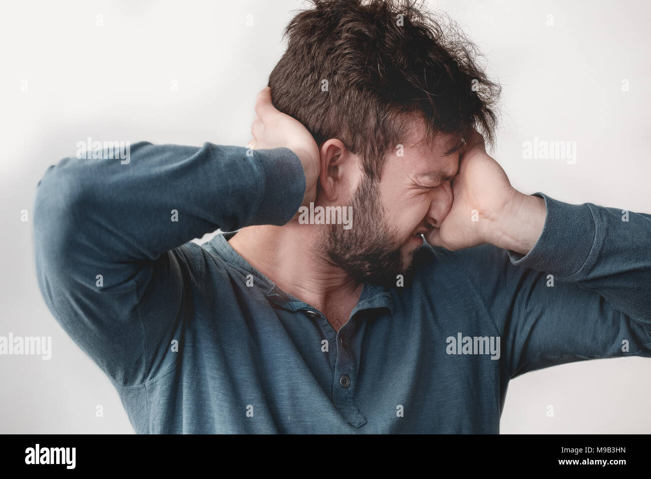 Man isolated on white wall facial expressions close-up smashing his ...