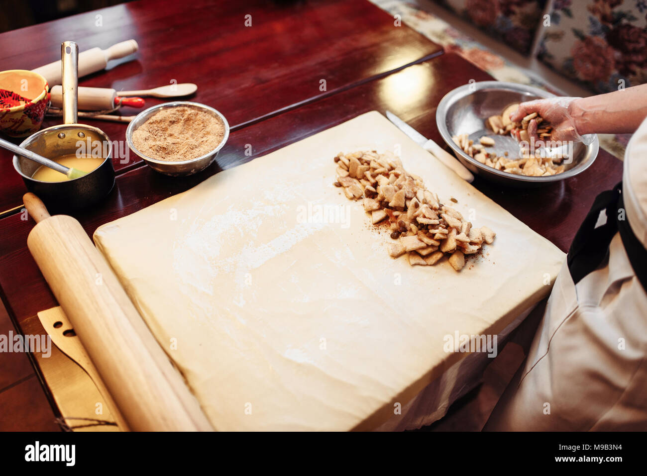 Male chef sprinkle the dough with cinnamon Stock Photo - Alamy