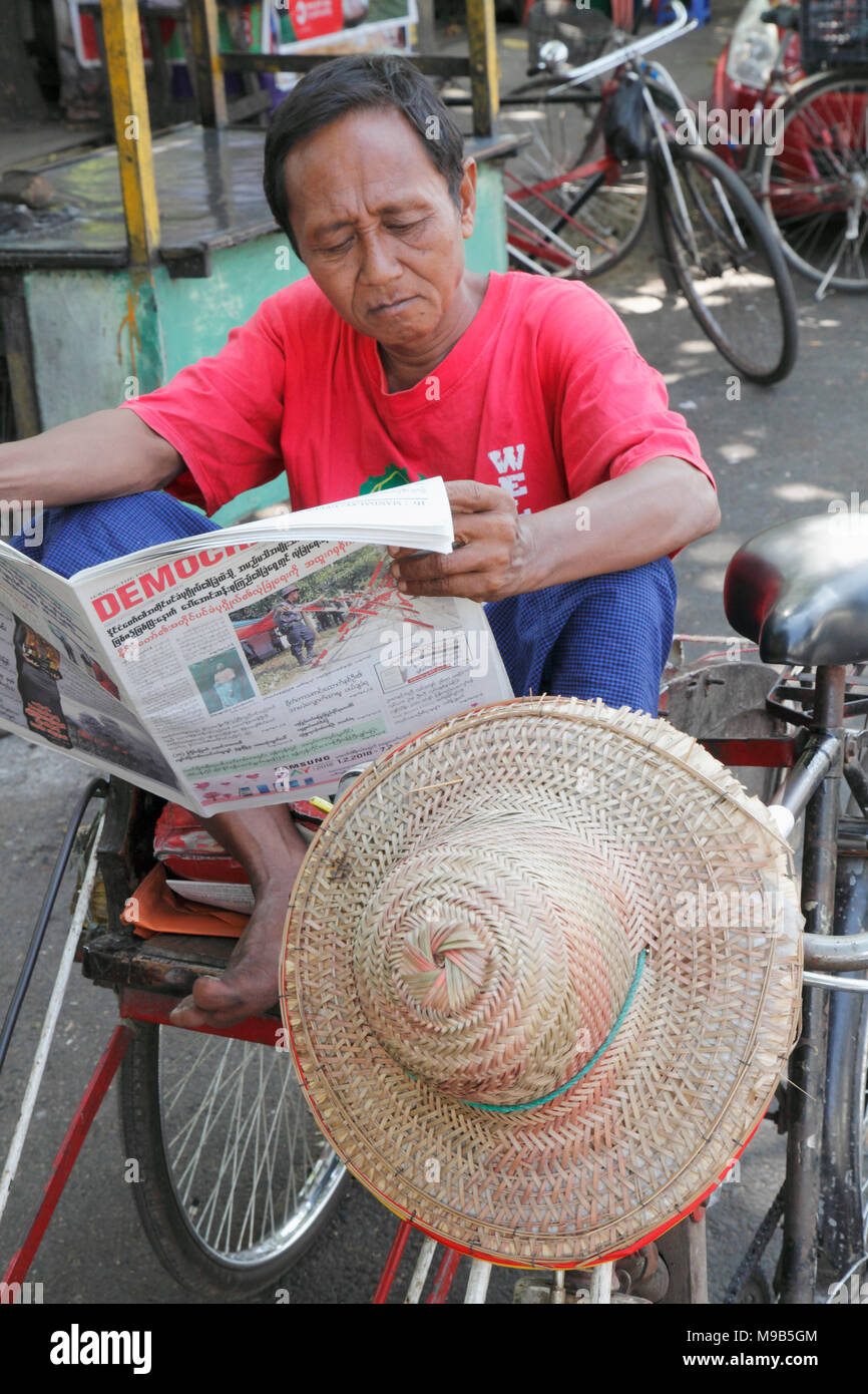 Myanmar, Yangon, man reading newspaper Democracy Today Stock Photo - Alamy