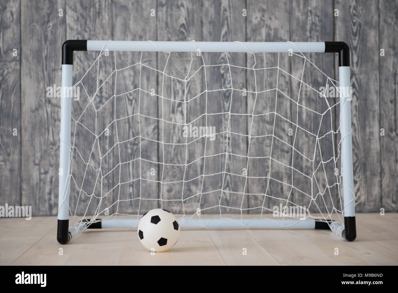 A soccer ball in a small gate on a gray background. Mini football Stock ...
