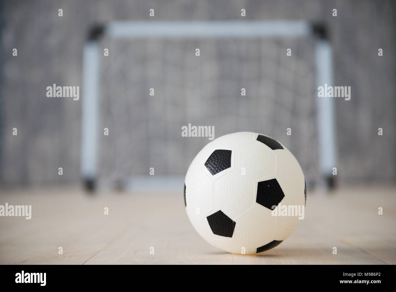 A soccer ball in a small gate on a gray background. Mini football Stock ...