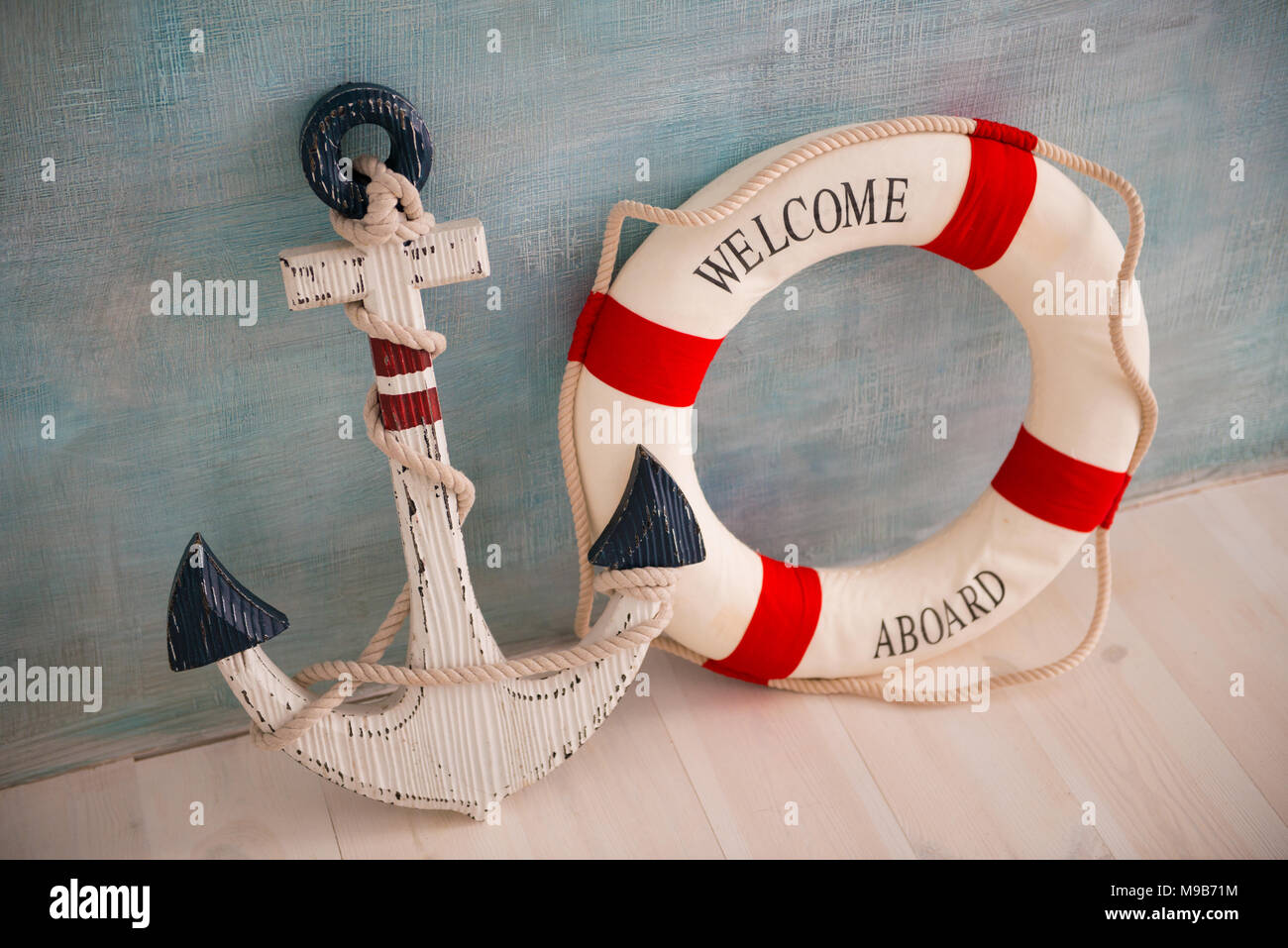 A composition on a sea theme with an anchor and lifebuoy on a blue wall ...