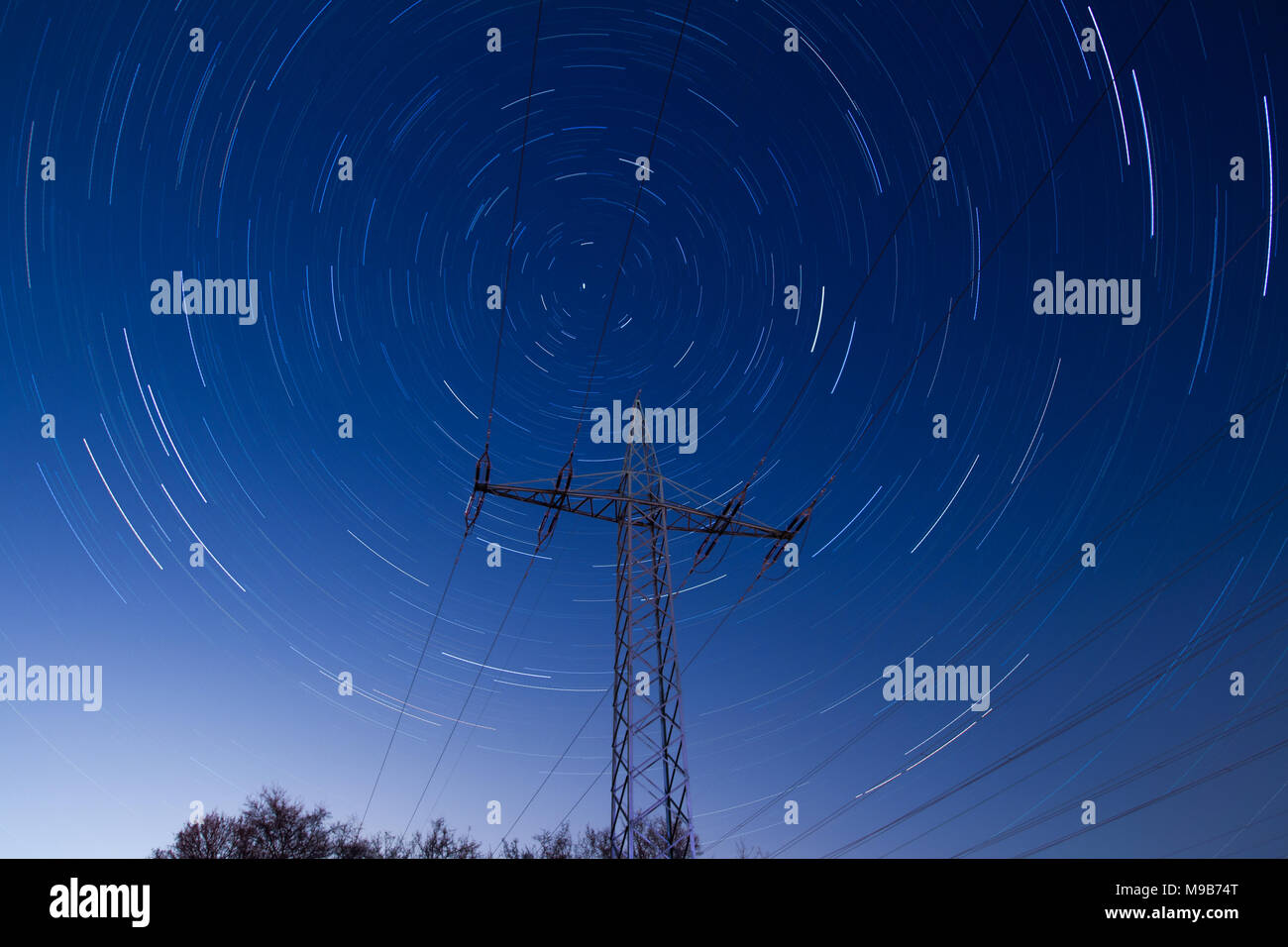 Northern startrails behind electricity pylon at night Stock Photo - Alamy