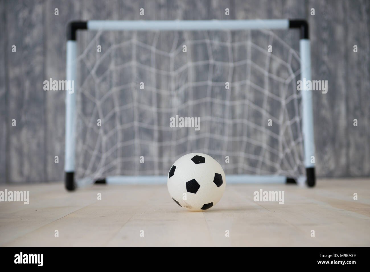 A soccer ball in a small gate on a gray background. Mini football Stock ...