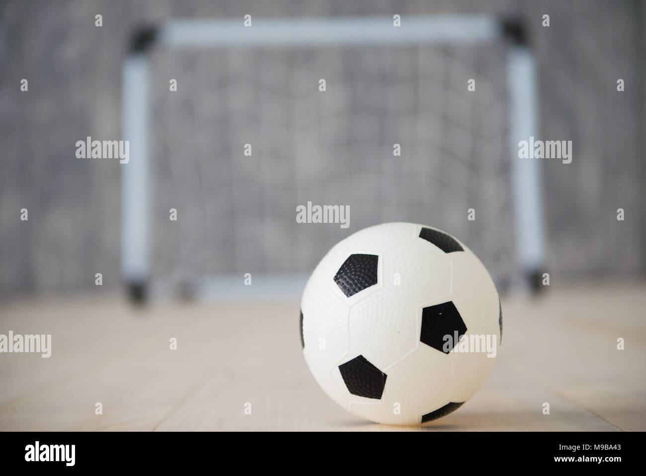 A soccer ball in a small gate on a gray background. Mini football Stock ...