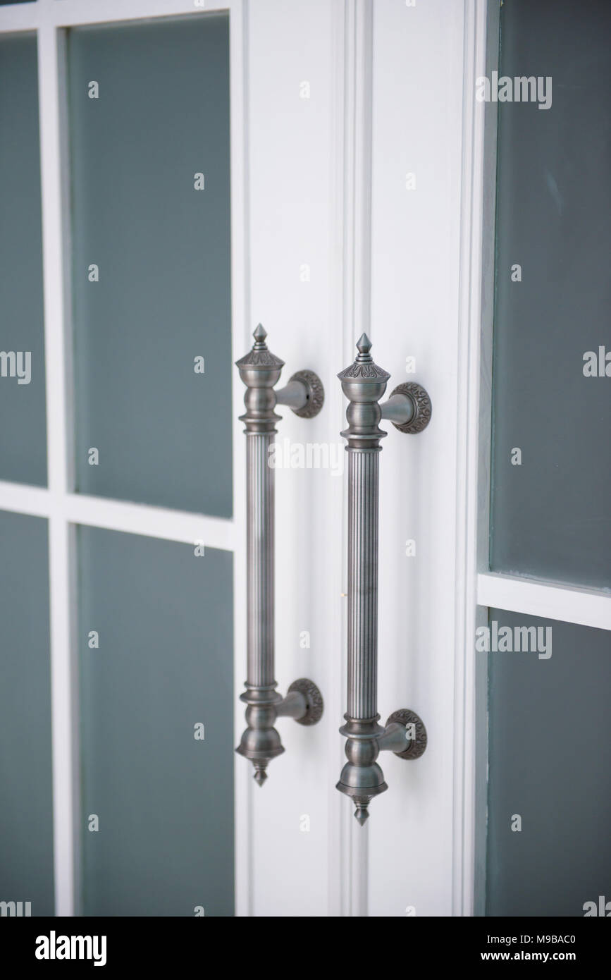 Closed white door with beautiful silver handles Stock Photo - Alamy