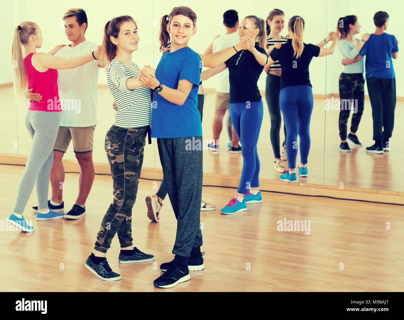Portrait of teen boys and girls having dancing class in classroom Stock ...