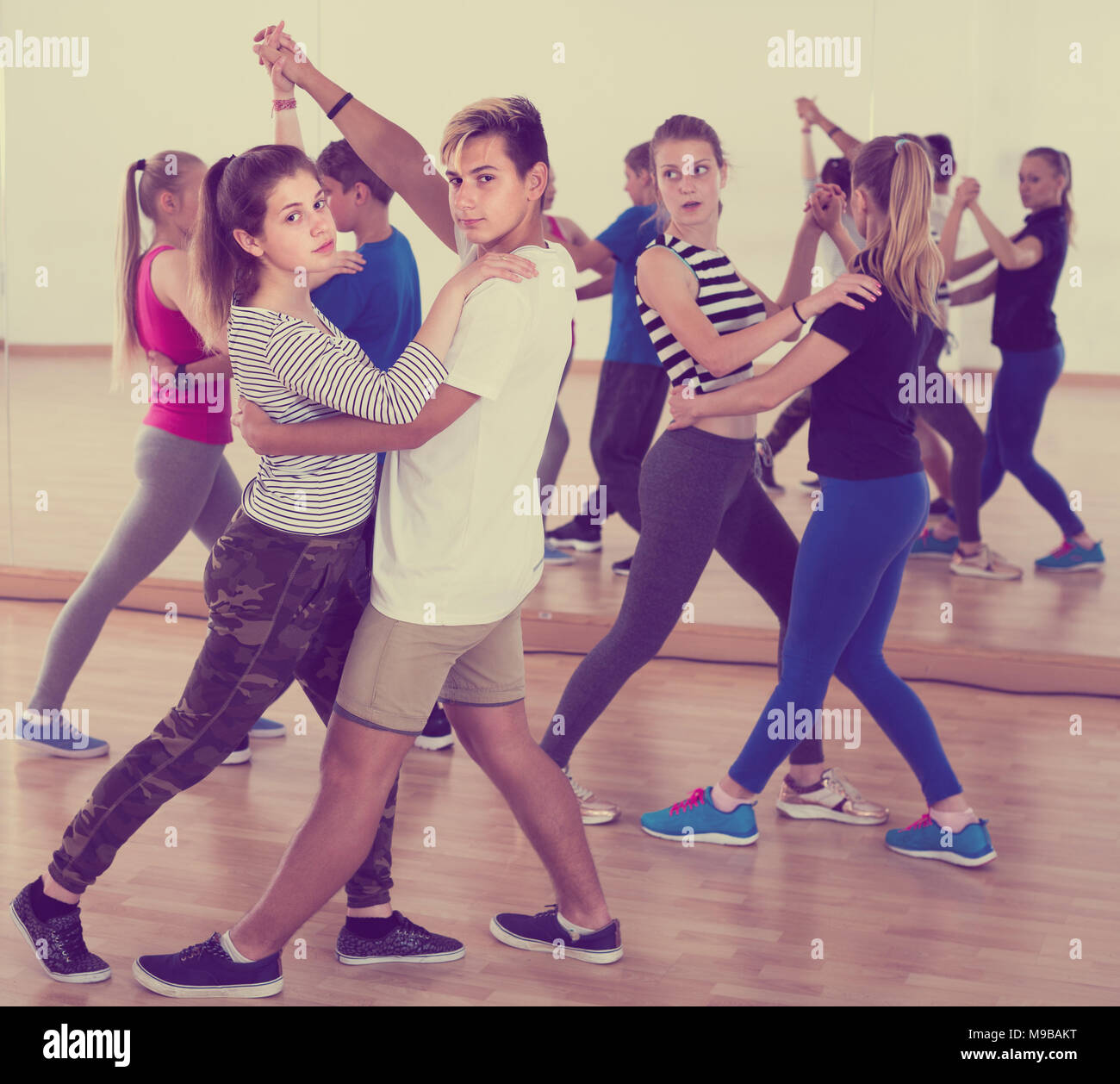 Portrait of teenage couples dancing of partner dance at dance school ...