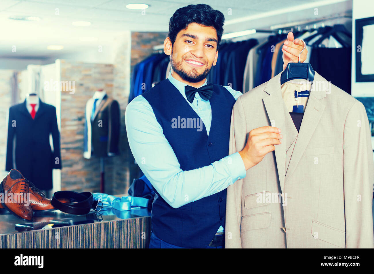 Male client demonstrating his choice of suit in shop Stock Photo - Alamy