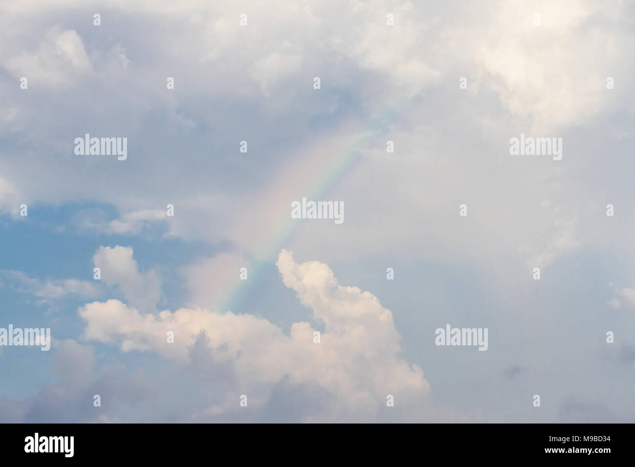 bright sun, blue sky background with rainbow, rainbow in cloud Stock Photo - Alamy