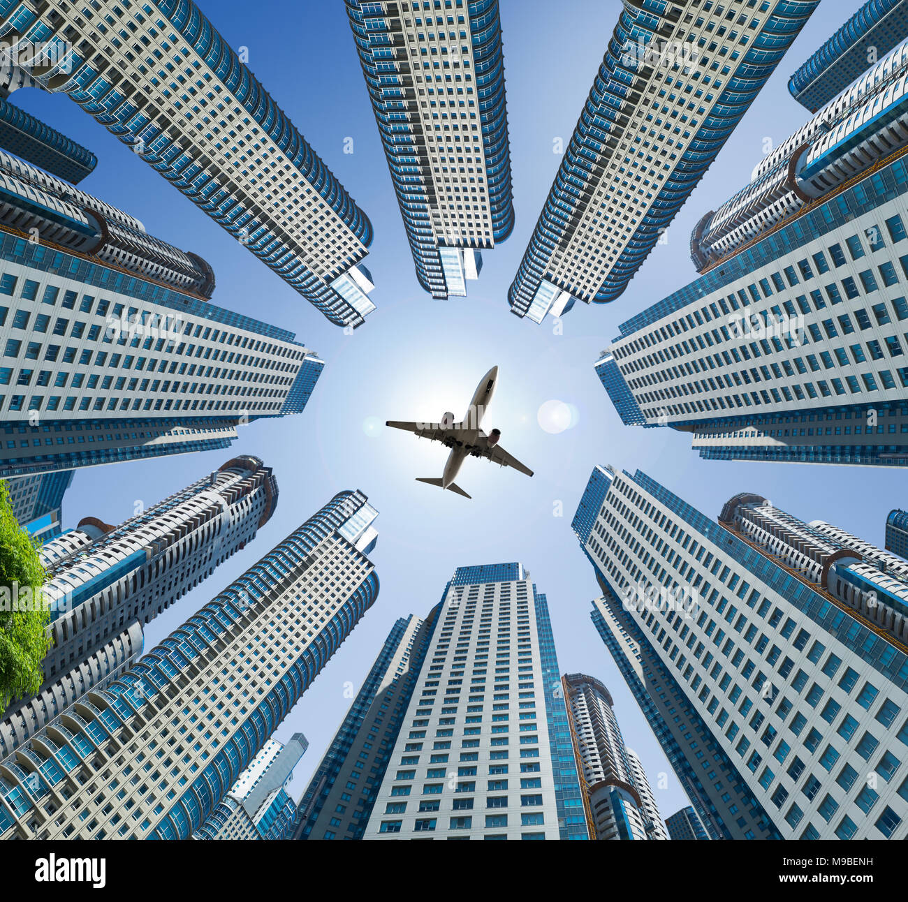 Plane soaring high in the sky encircled by skyscrapers Stock Photo - Alamy