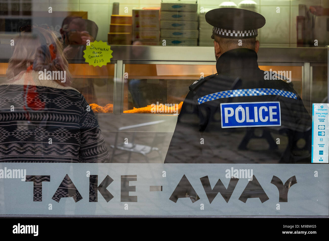 A police officer on the beat in uniform resting and eating lunch ...