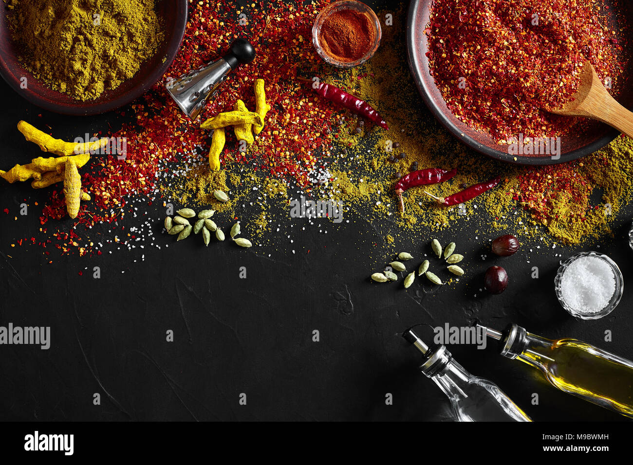 Cooking using fresh ground spices with big and small bowls of spice on ...