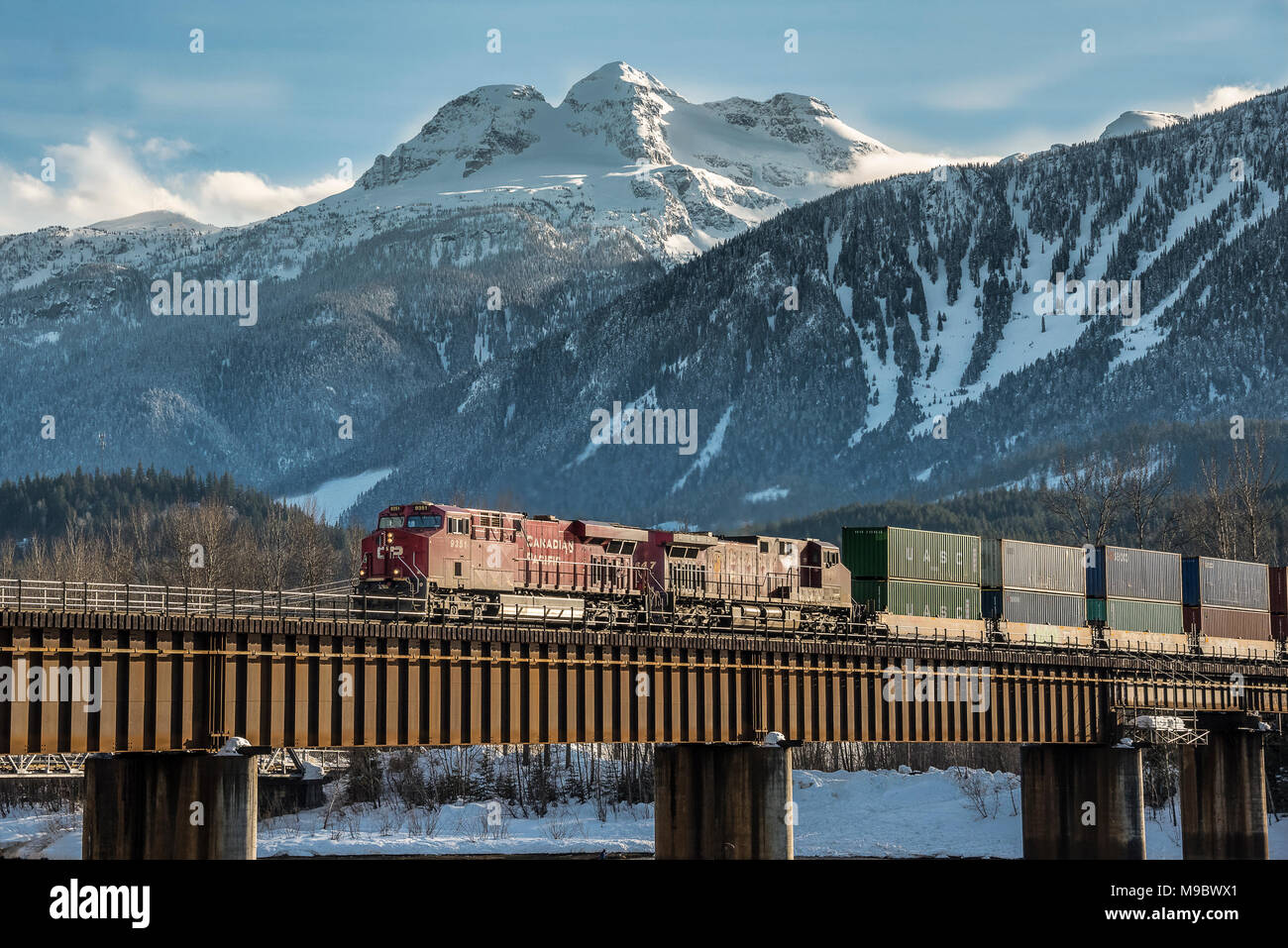 CPR loco 9351 leads intermodal train in winter through wooden snow ...