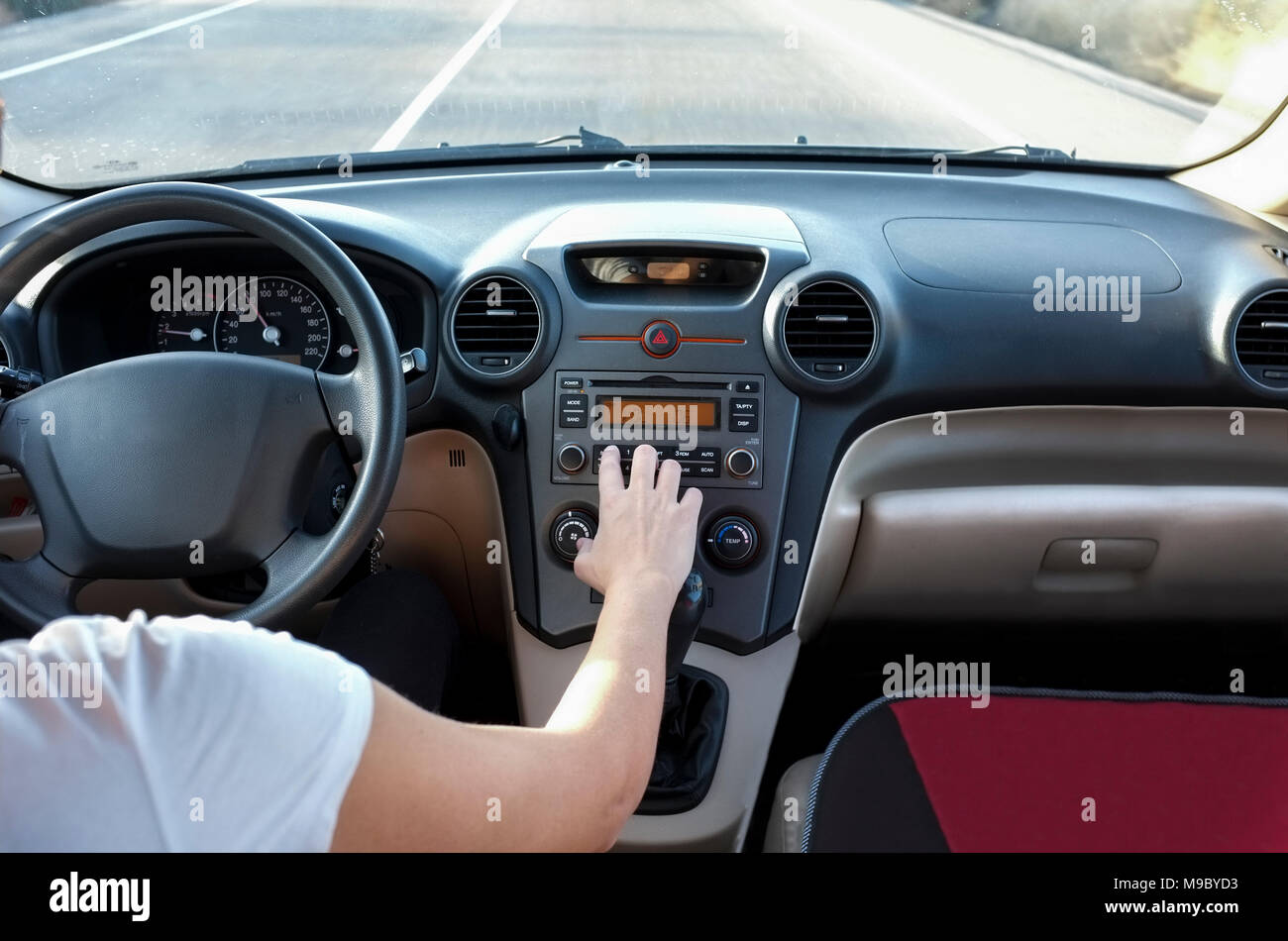 Woman adjusting volume at car audio system while she is driving. Cause ...