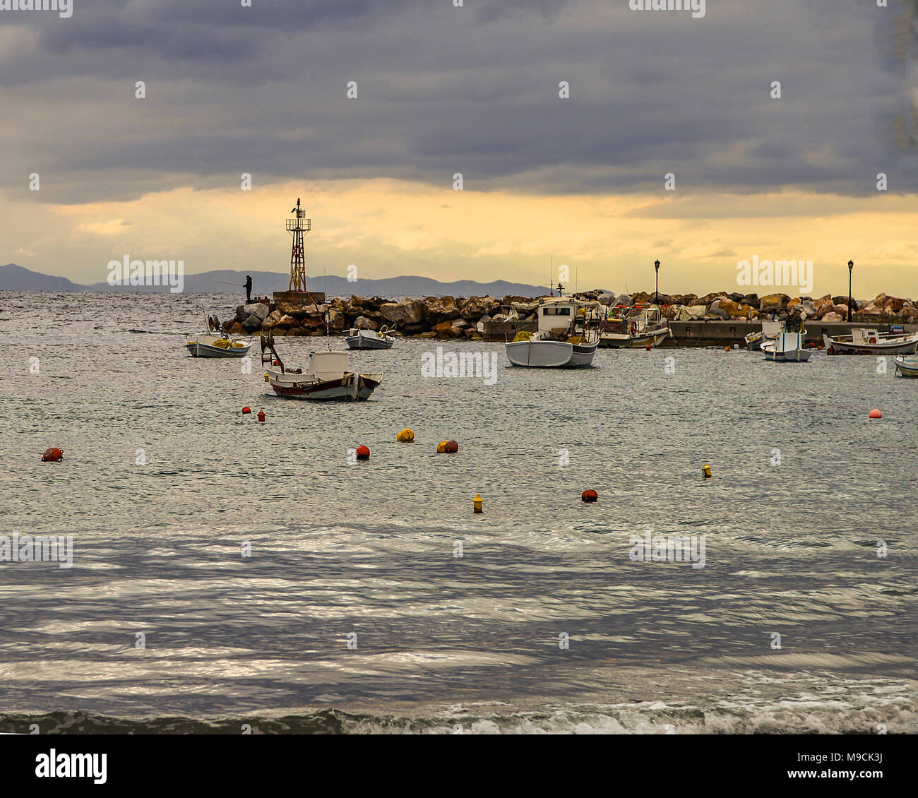 Small fishing boats moored in small bay in Kini Greece .Silhouette of a ...