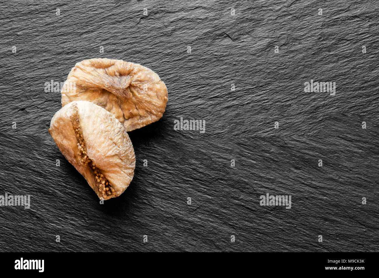 Dried figs on back stone surface background Stock Photo - Alamy