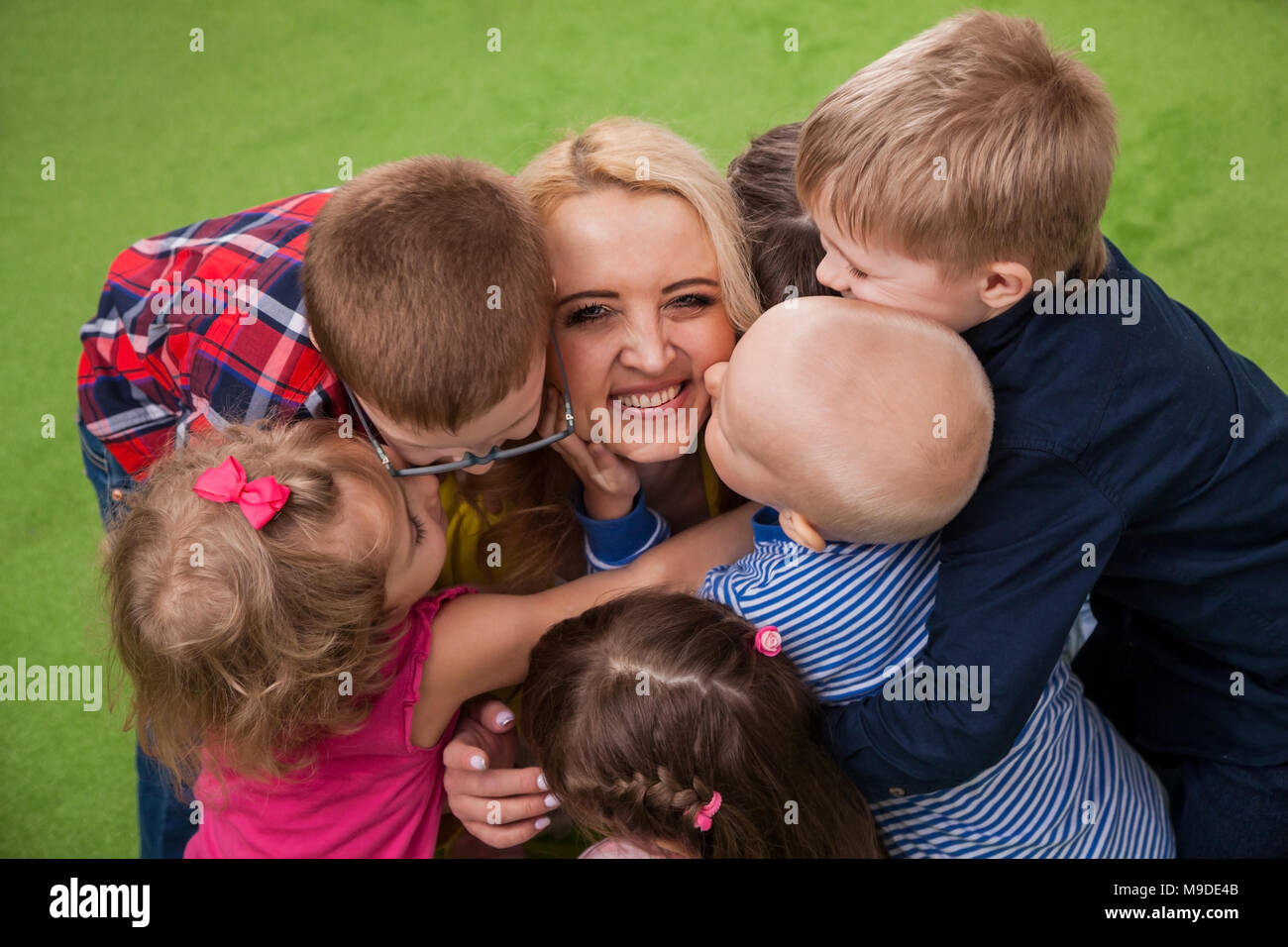 Children hugging teacher Stock Photo - Alamy