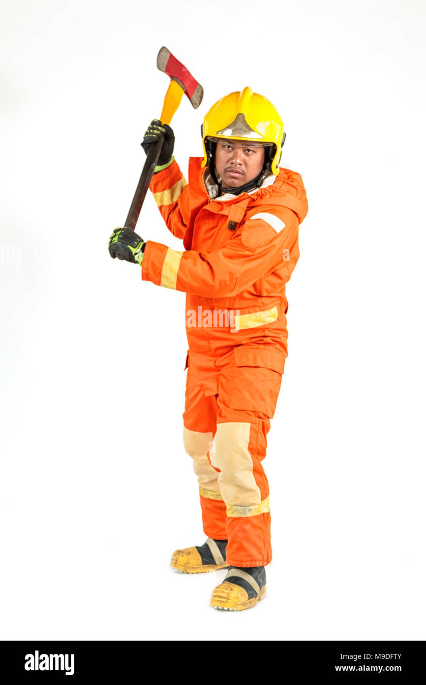 Firefighter in uniform and safety helmet standing holding axe full body ...