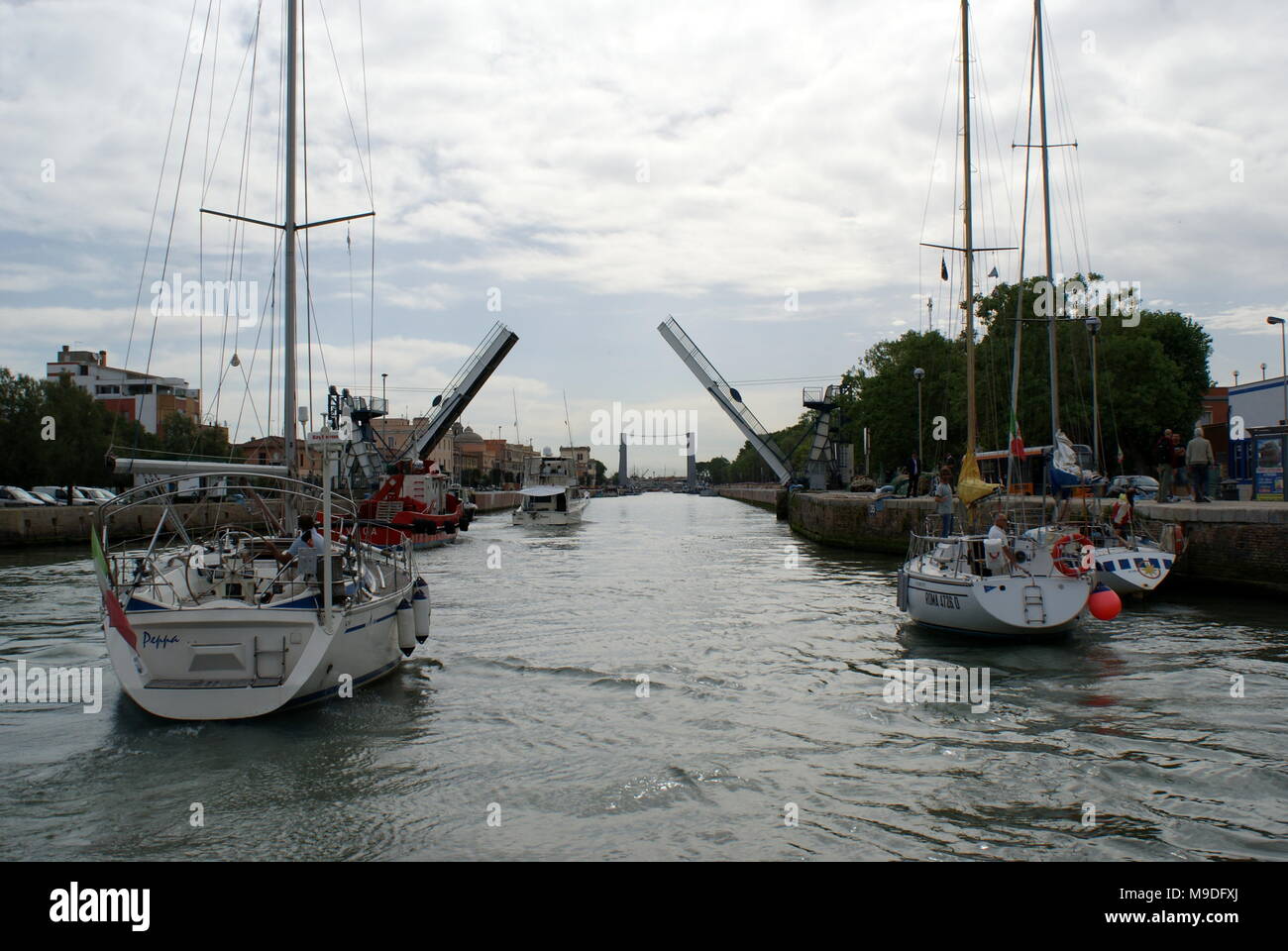 Yachts approaching the lifting pedestrian bridge, Fiumicino canal ...