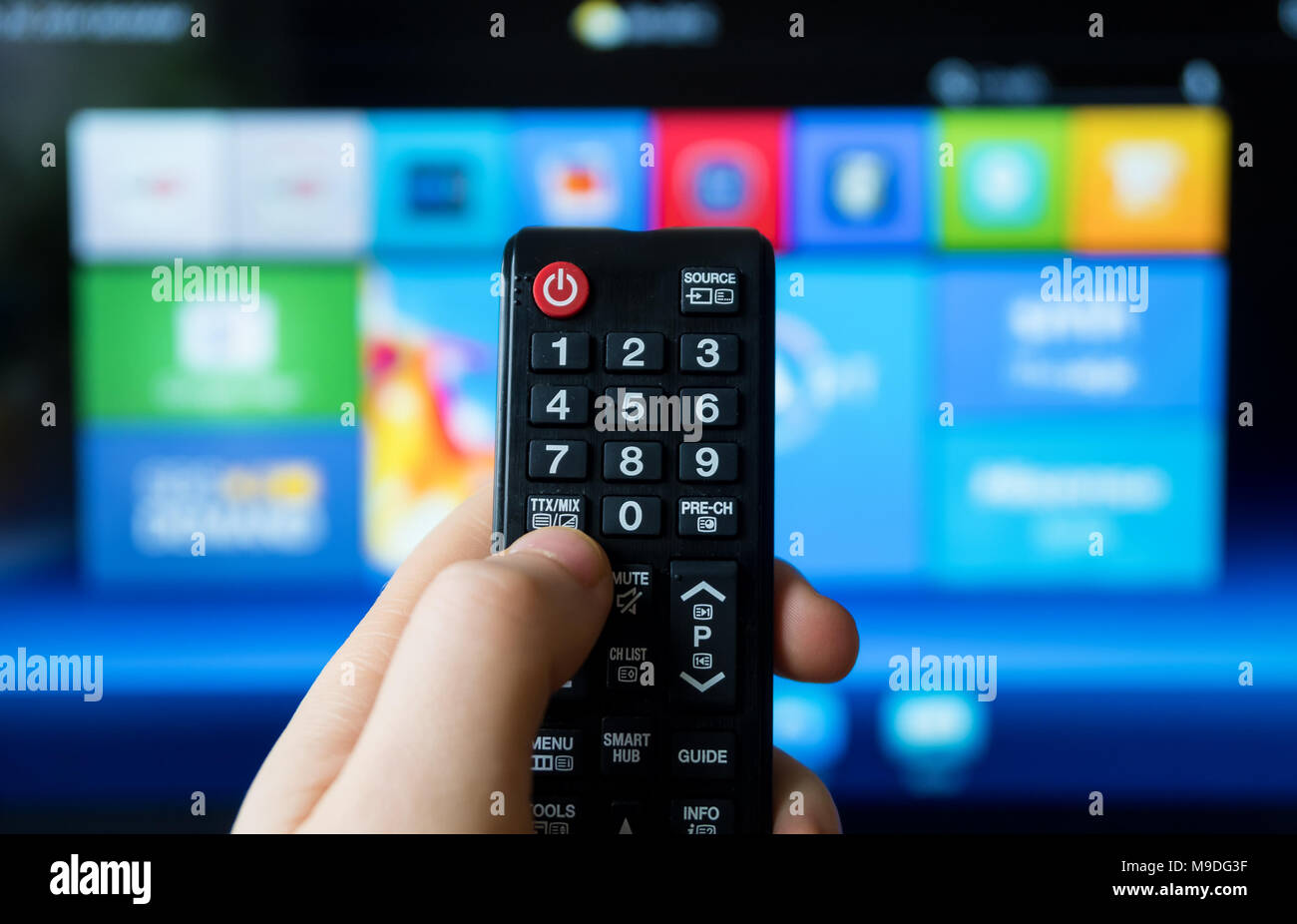 Male hand holding TV remote control. Smart TV Stock Photo - Alamy