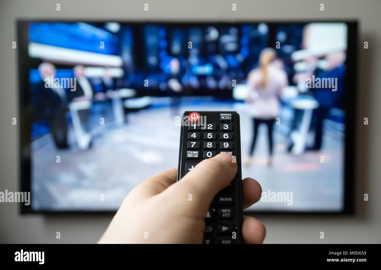 Male hand holding TV remote control. Talk show Stock Photo - Alamy