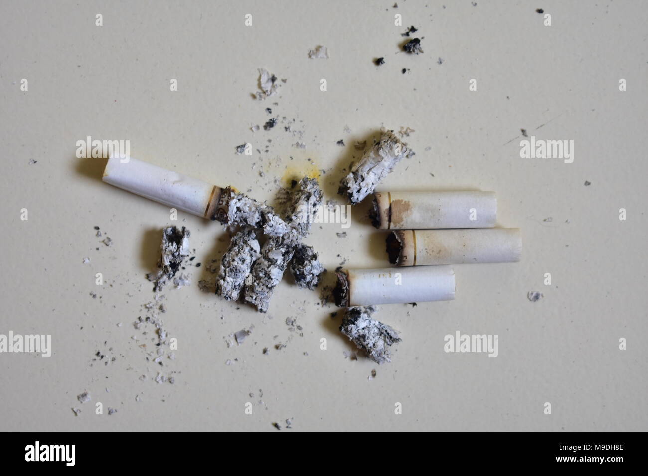 A lot of cigarette piece with ash after smoking shattered on the floor ...