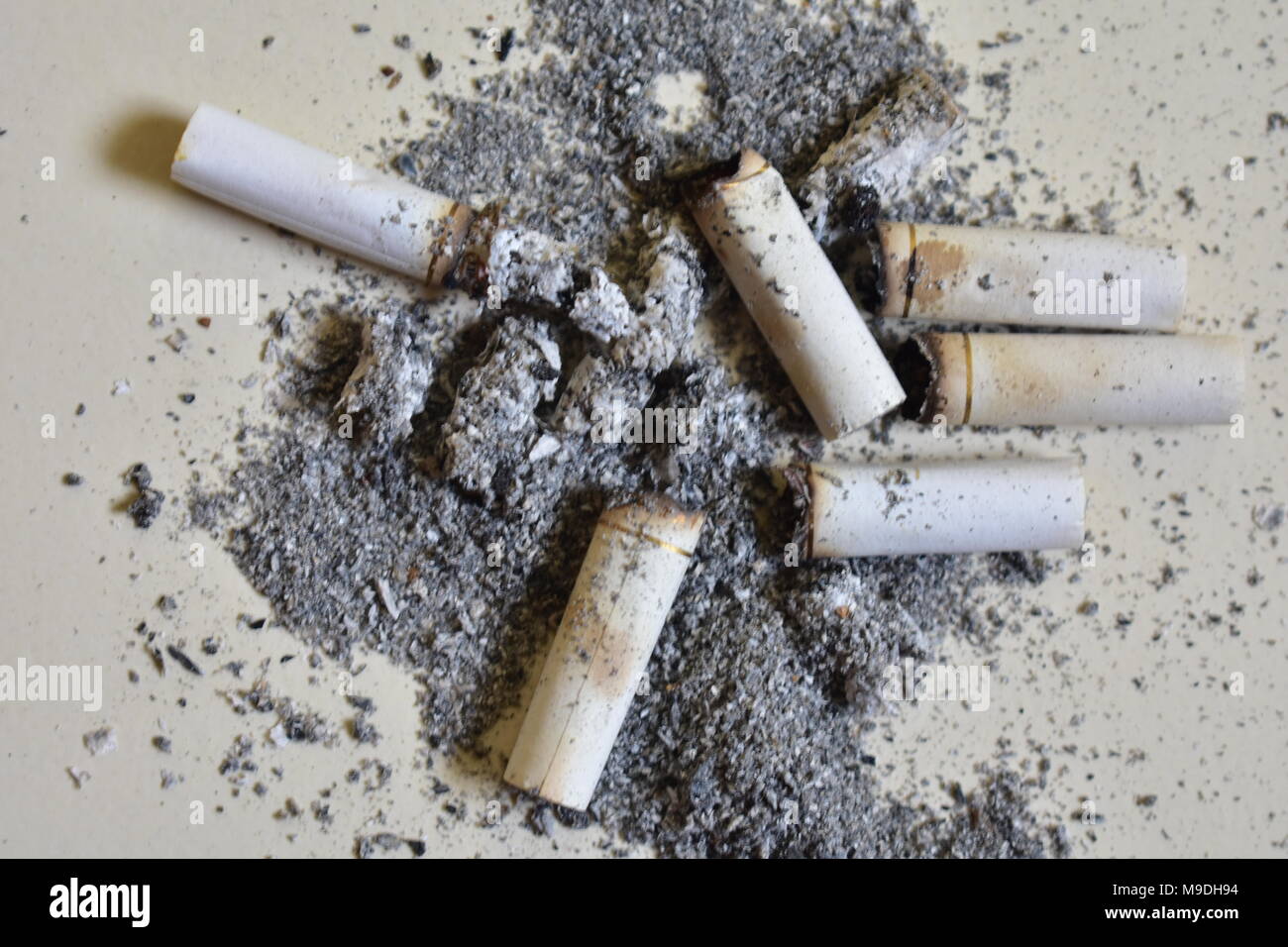 A lot of cigarette piece with ash after smoking shattered on the floor ...