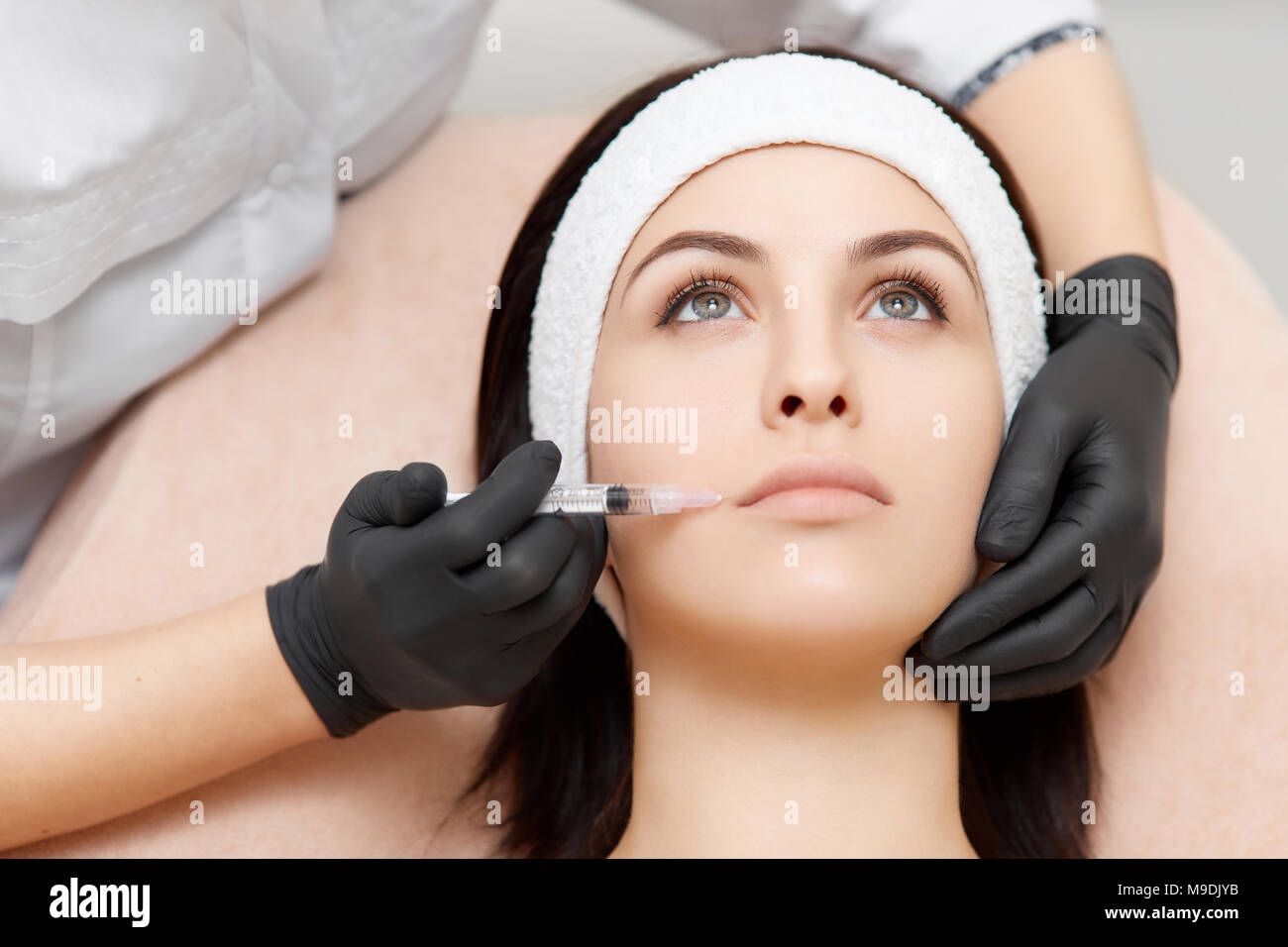 Beautiful young woman getting injection in her face Stock Photo - Alamy