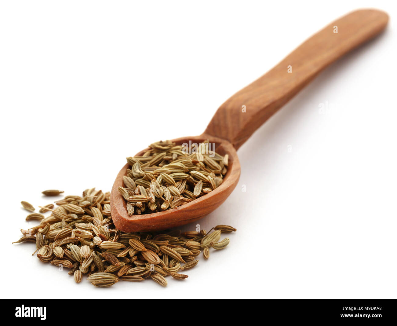 Fennel seeds in wooden scoop over white background Stock Photo - Alamy