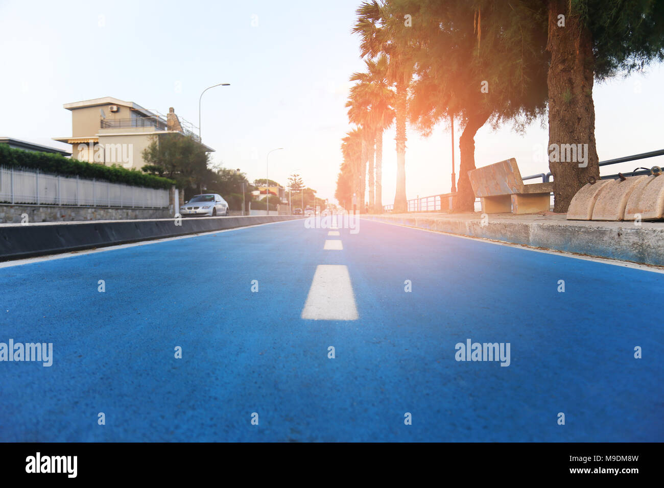 Separate blue bike lane near beach at ocean resort. Cycling path for ...