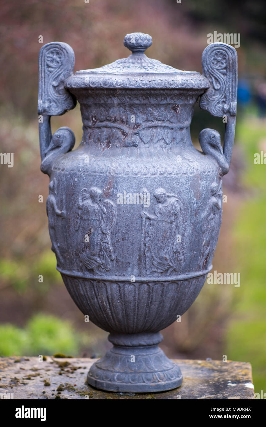 stone Greek urn isolated in English country garden with blurred ...