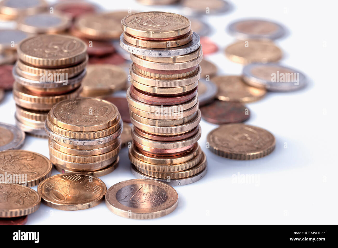 Many euro coins stacked in columns on white background Stock Photo - Alamy
