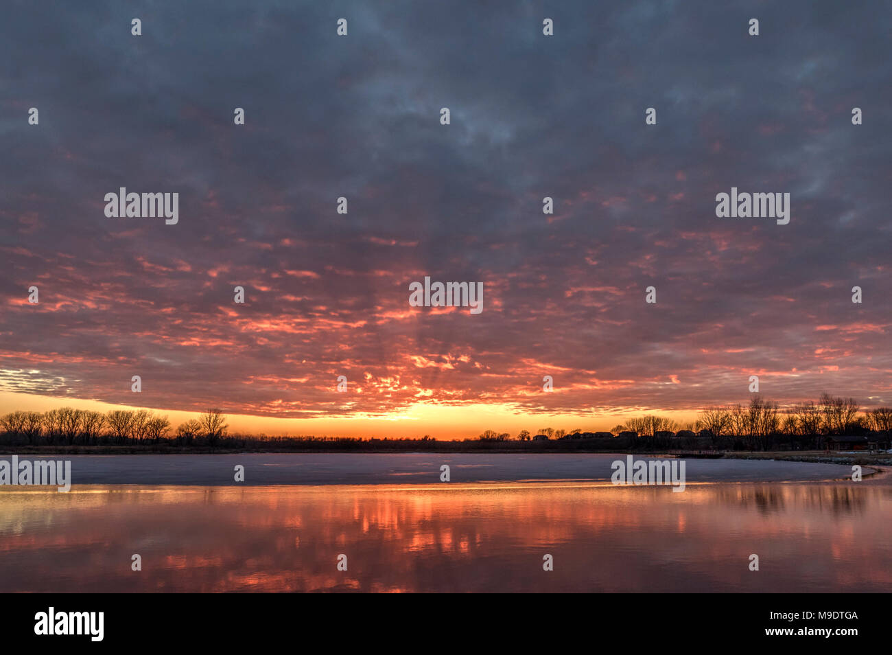 Winter sunset at the partially frozen Ada Hayden Lake, Ames, Iowa, USA ...