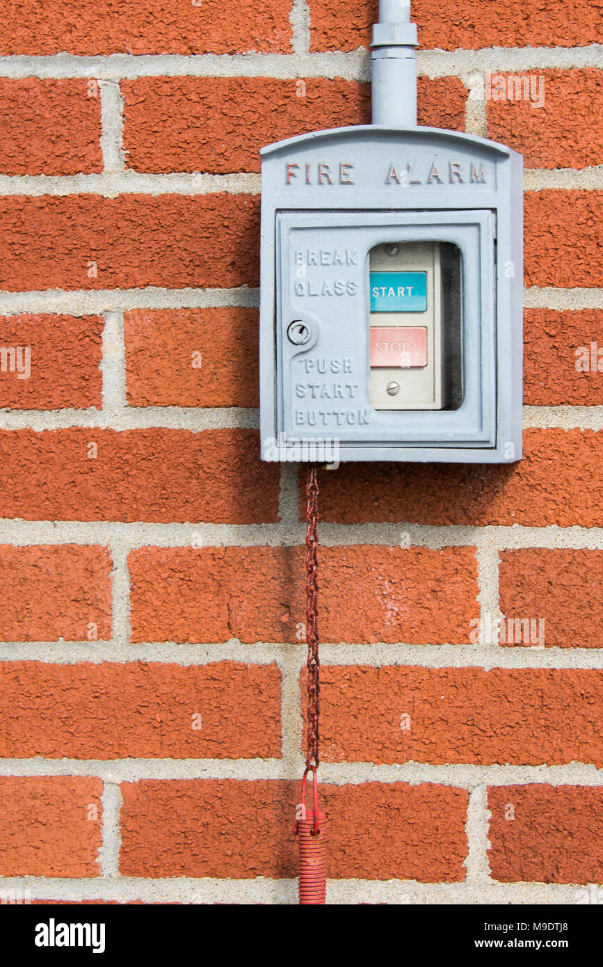 A fire alarm mounted on a brick wall outside the fire station in ...