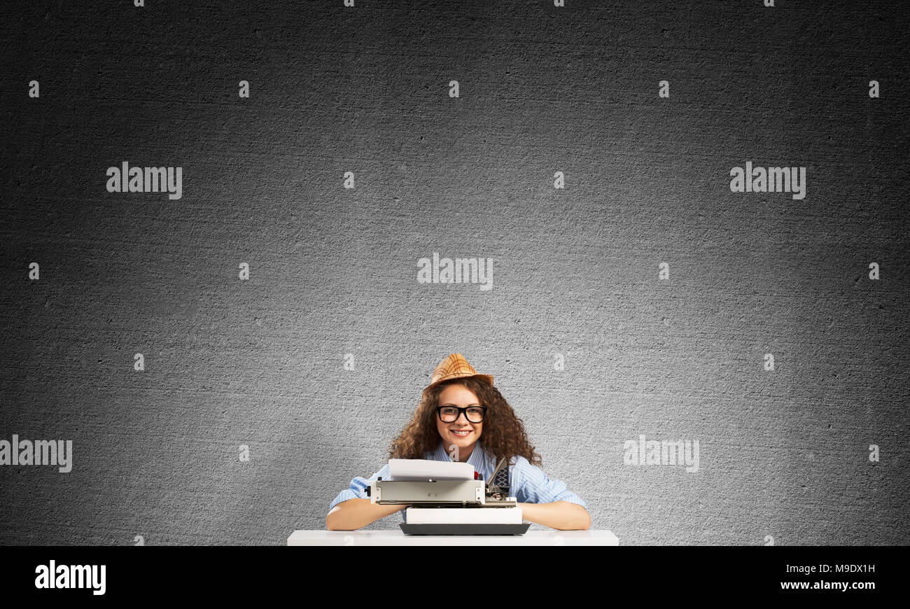 Young and beautiful woman writer in hat and eyeglasses using typing ...