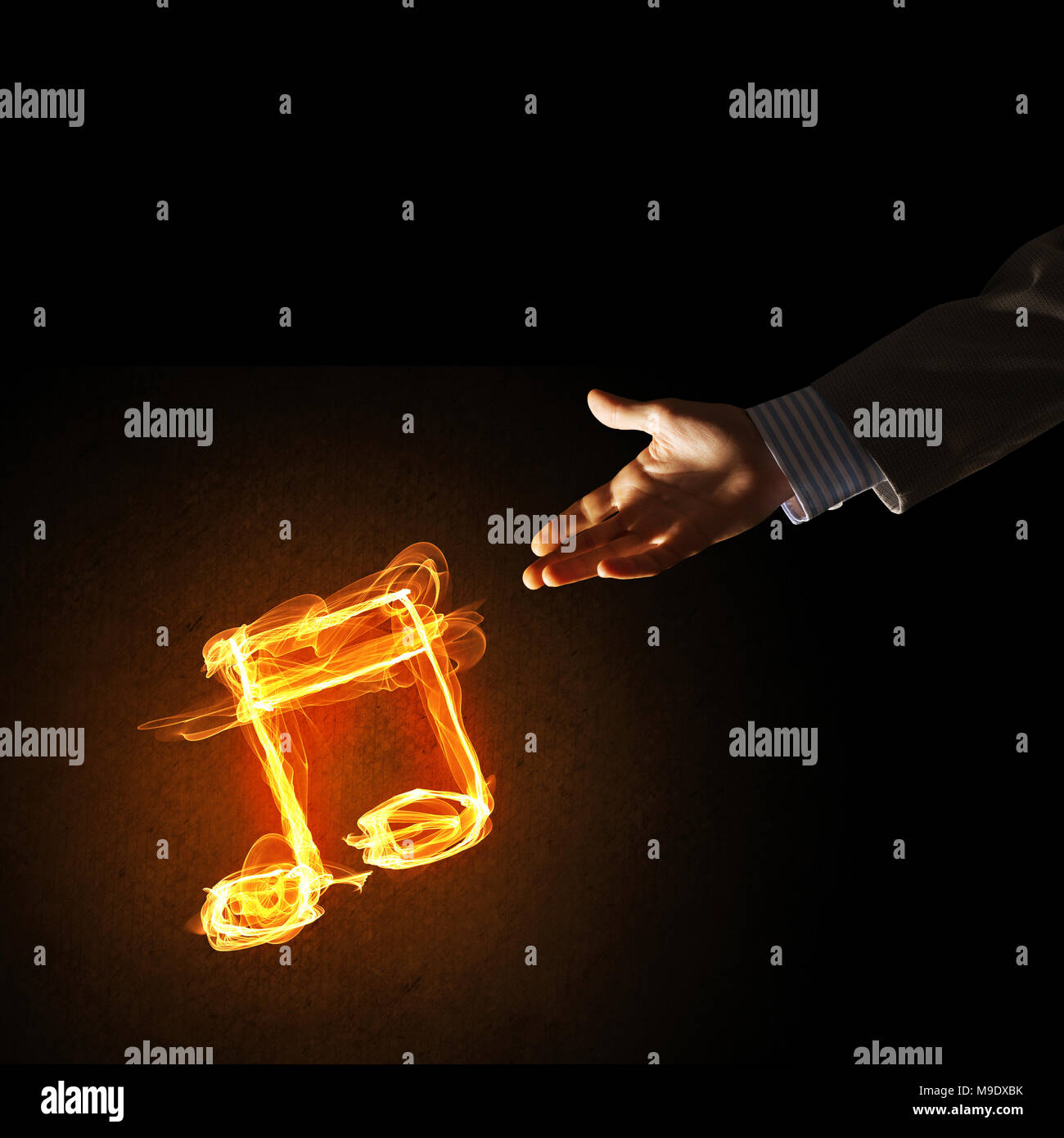 Close up of person hand and fire music symbol on dark background Stock ...