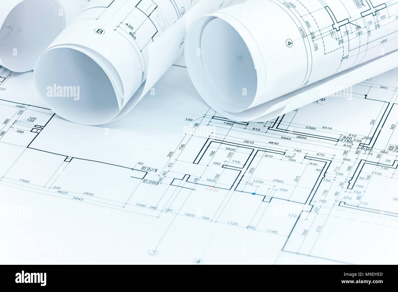 set of construction plans and blueprint rolls with technical project ...