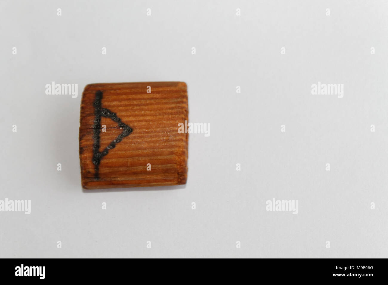Wooden rune which means the god Thor, giant, lie on a table on a white ...