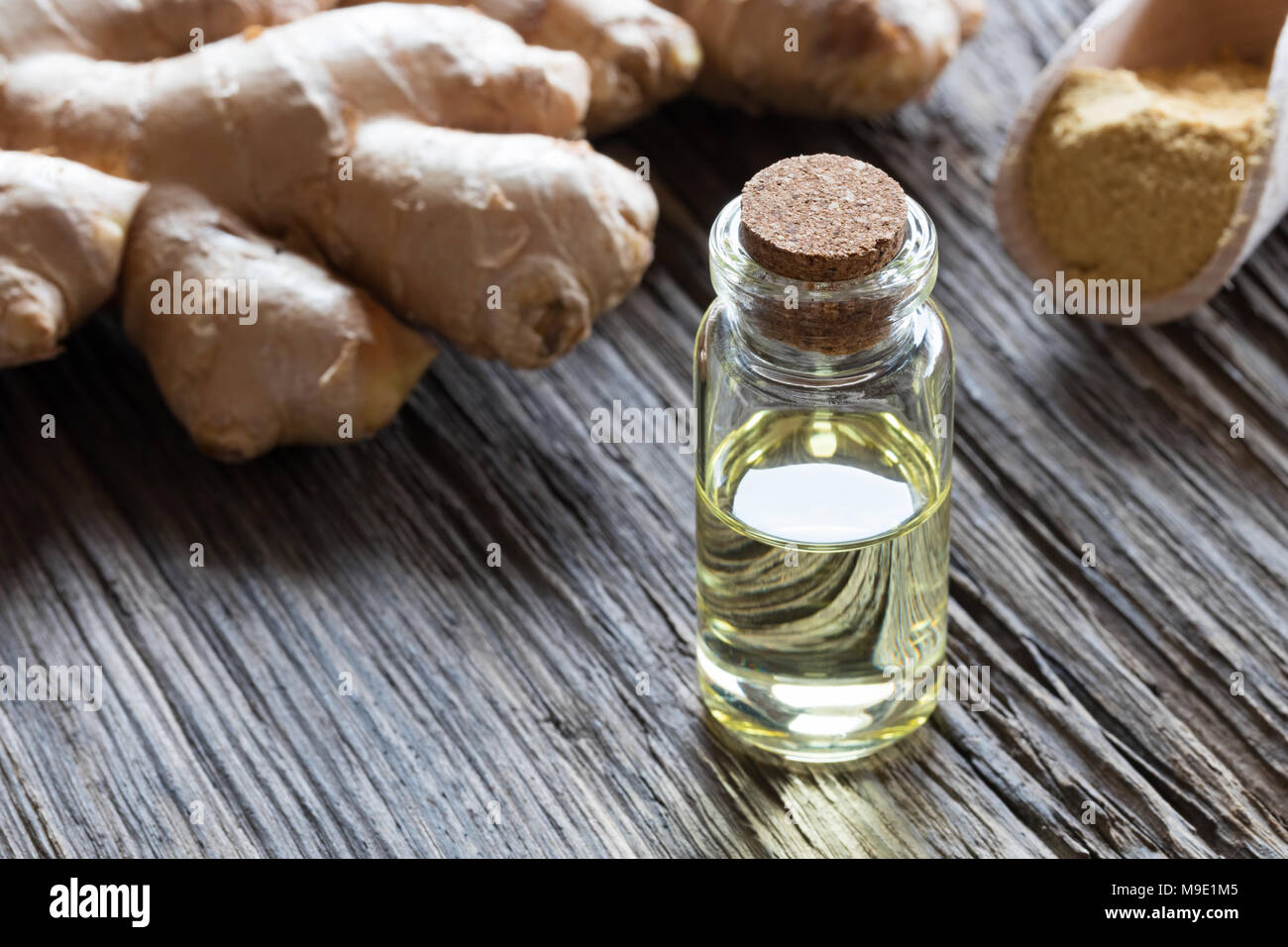 A bottle of ginger essential oil with fresh and dried ginger in the ...