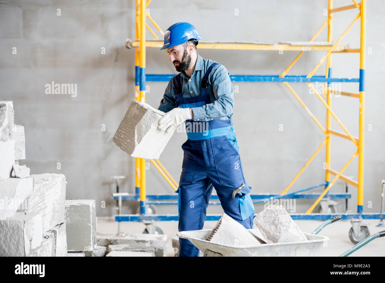 Builder working with blocks indoors Stock Photo - Alamy