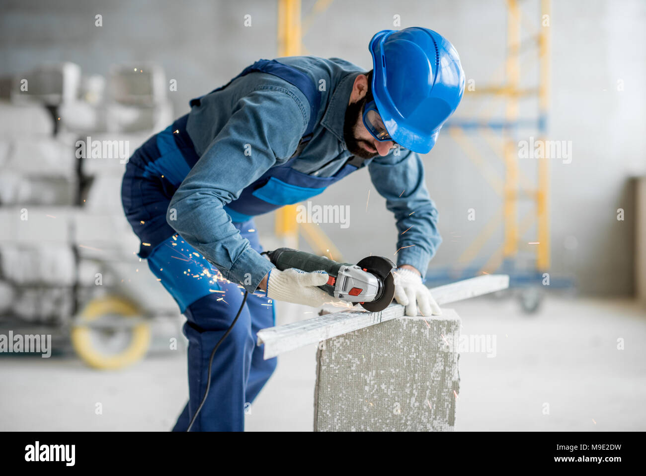 Builder cutting metal indoors Stock Photo - Alamy