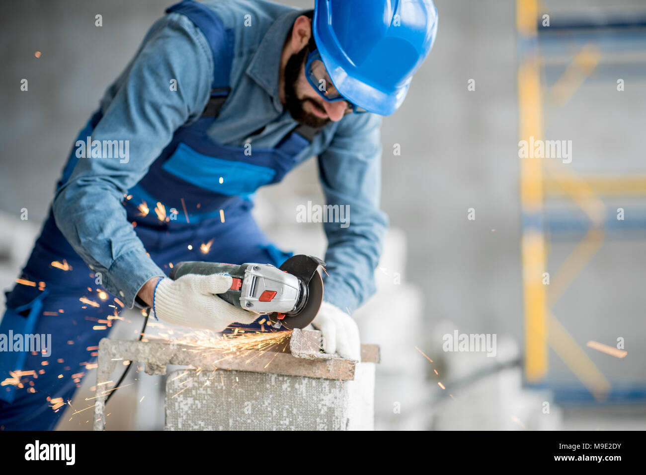 Builder cutting metal indoors Stock Photo - Alamy