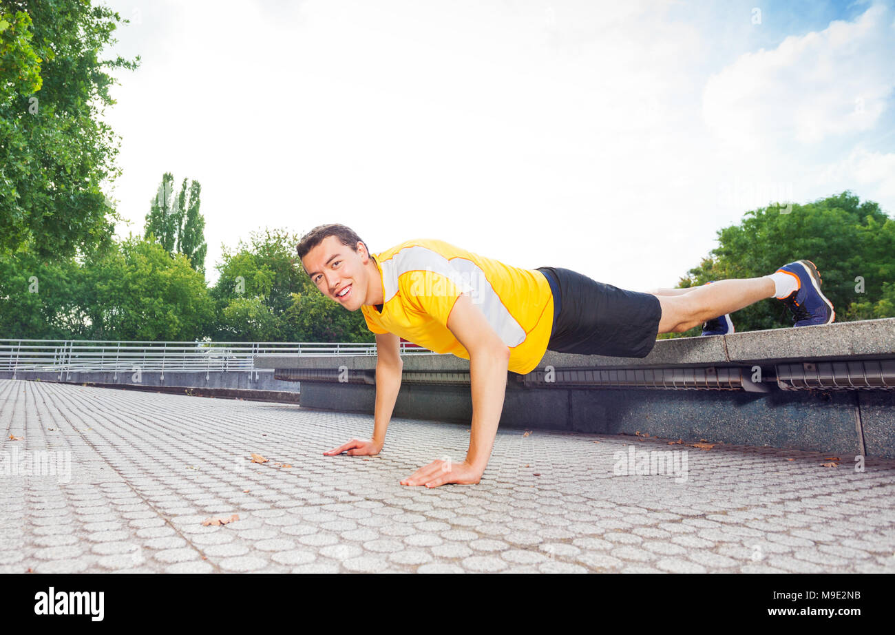 Sporty young man doing plank exercise outdoors Stock Photo - Alamy
